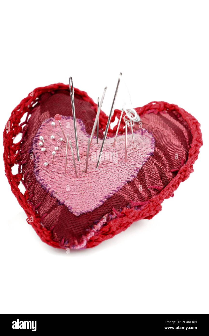 Pink and red heart shape with needles and thread isolated on white ...