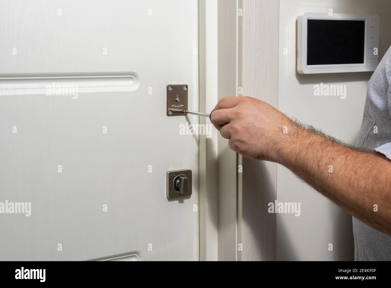 master repairing a door lock in a room, a man fixing a lock with a ...
