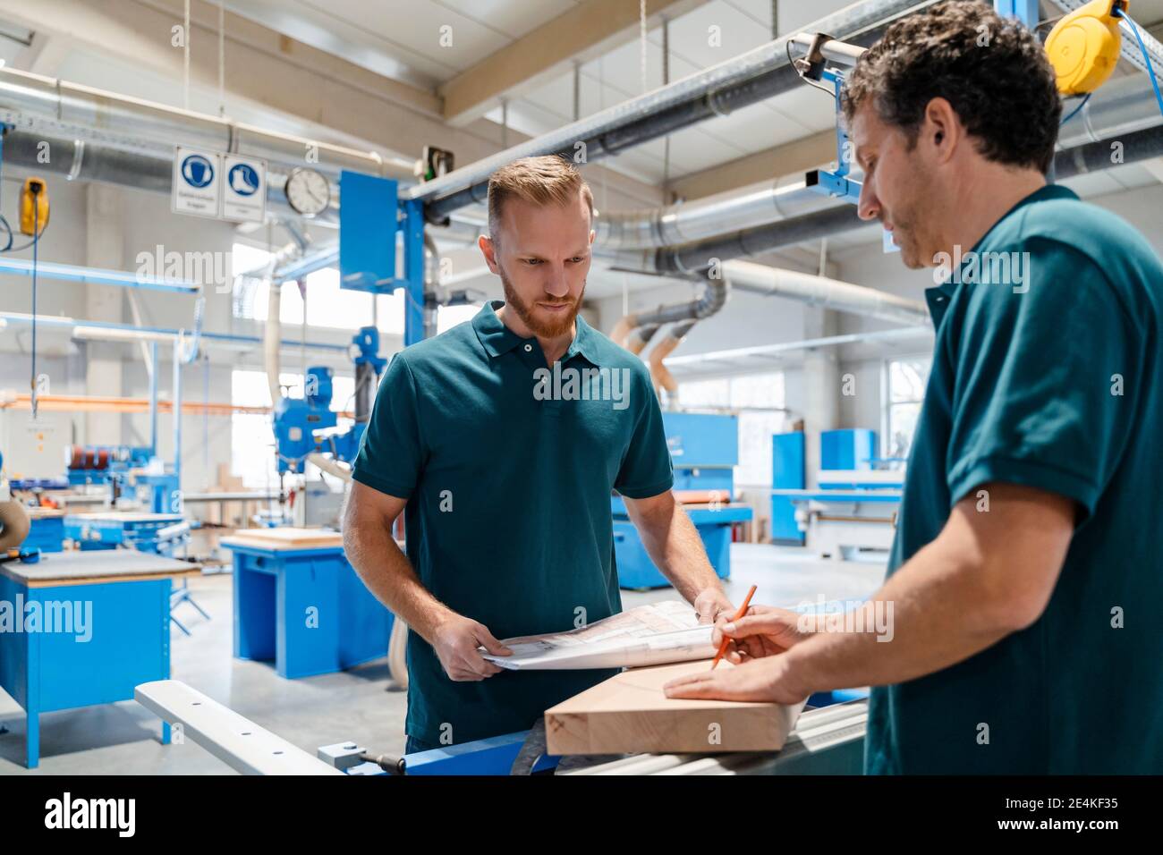 Two male carpenters working together in production hall Stock Photo - Alamy