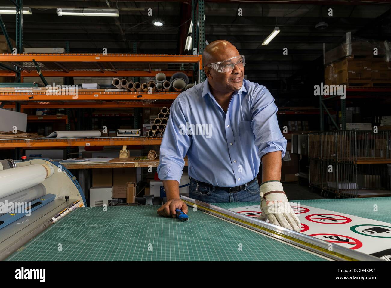 Male supervisor cutting paper signs on workbench Stock Photo - Alamy