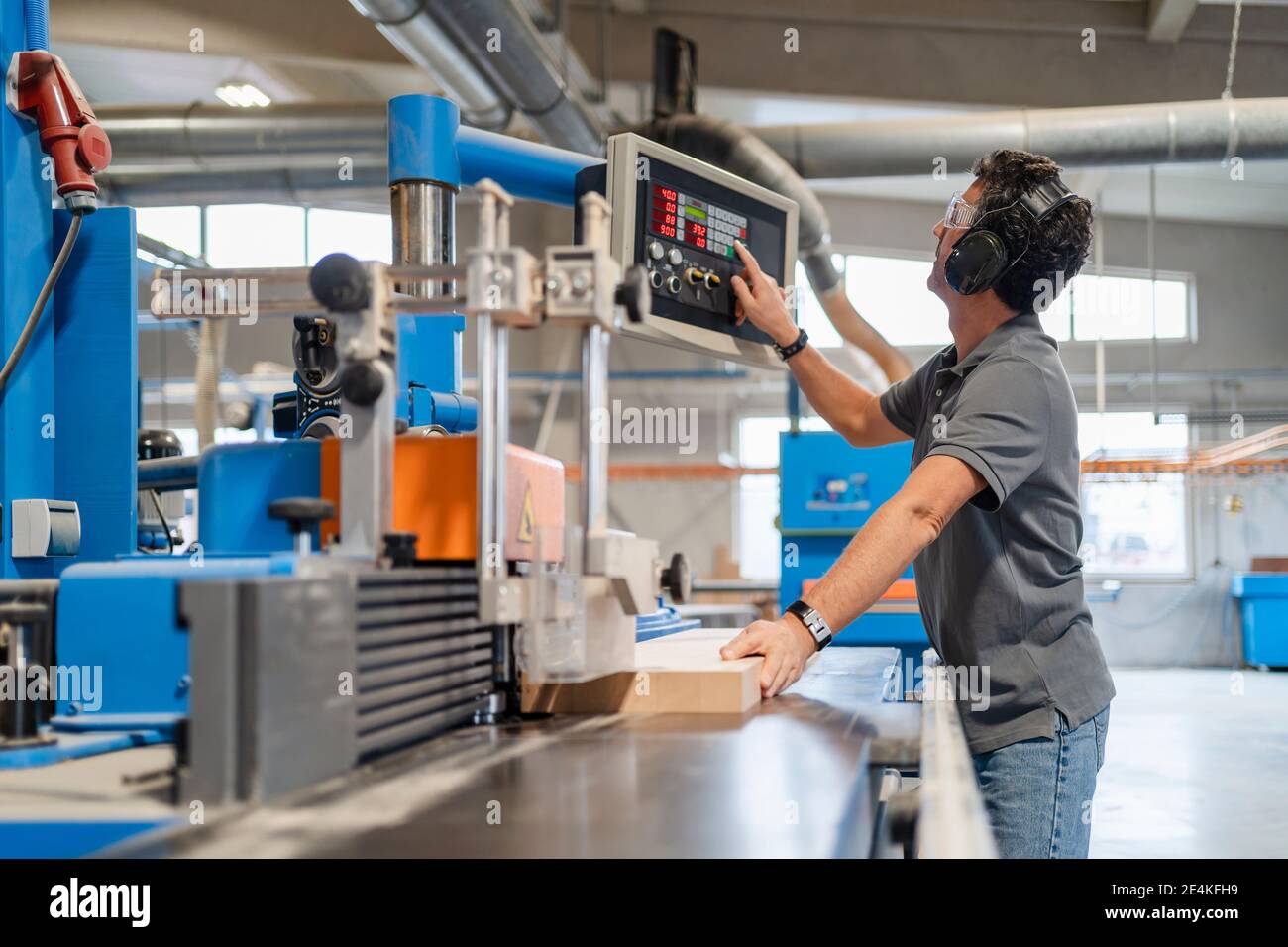 Carpenter operating control panel in production hall Stock Photo - Alamy