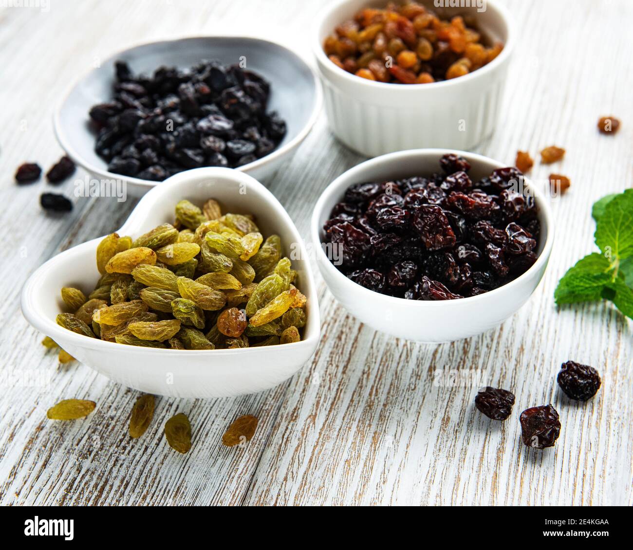 Collection of various raisins on a white wooden background Stock Photo ...
