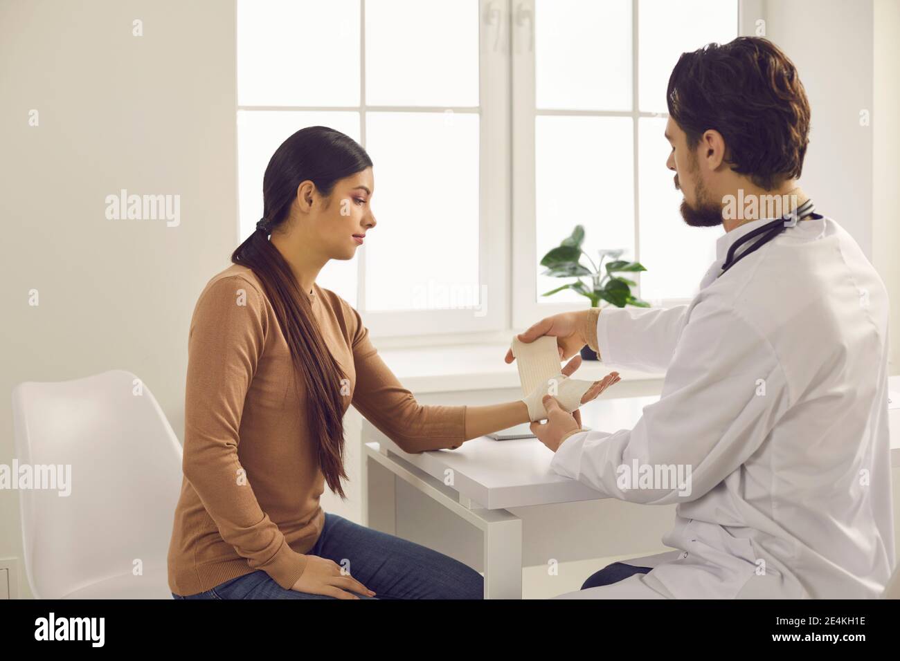 Professional doctor at the hospital wrapping young woman's injured ...