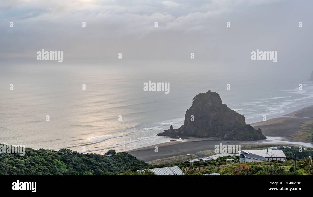 Long view of South Piha beach with Lion Rock with hazy ocean horizon ...