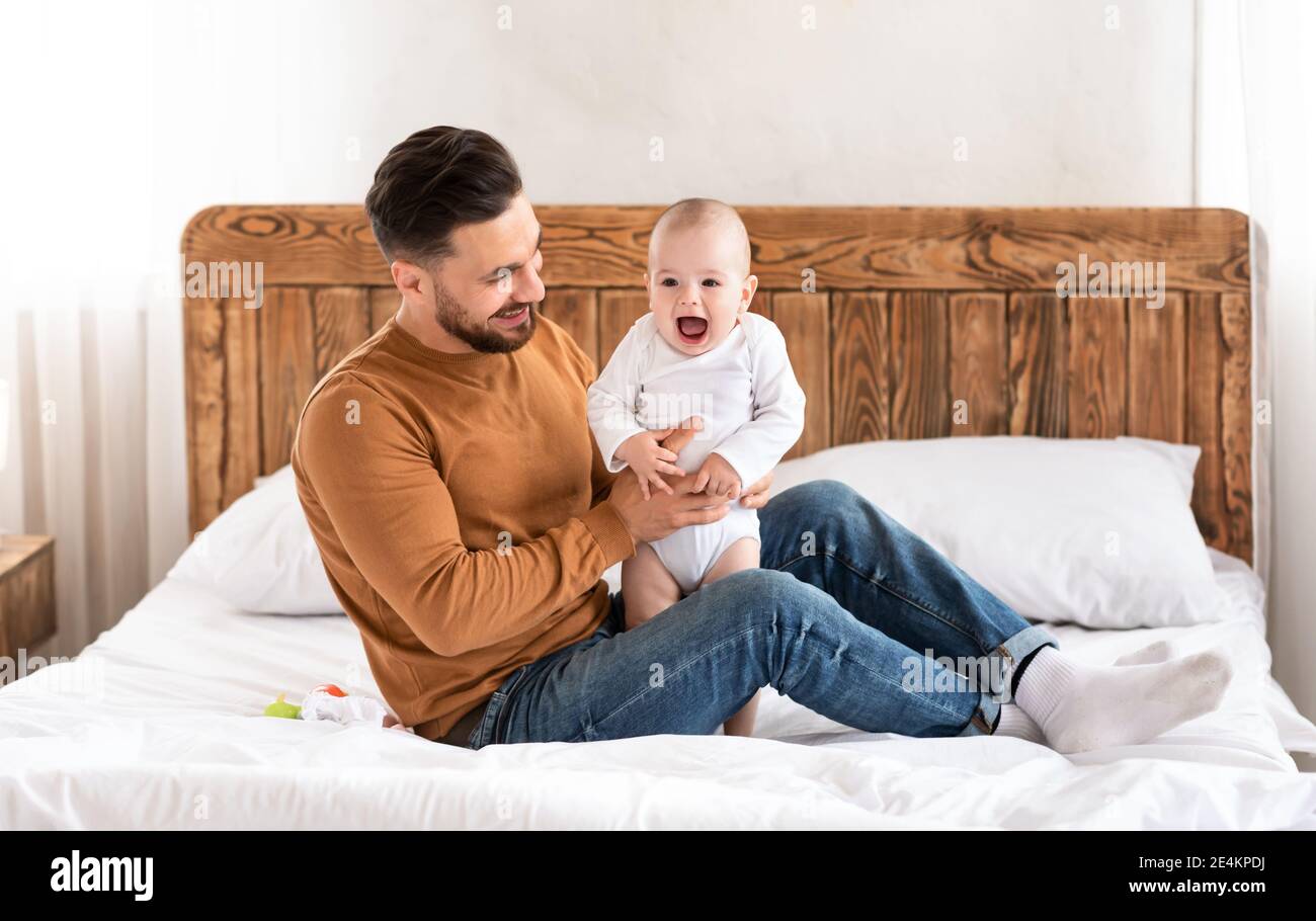 Happy Young Dad Playing With Baby Toddler Bonding In Bedroom Stock ...