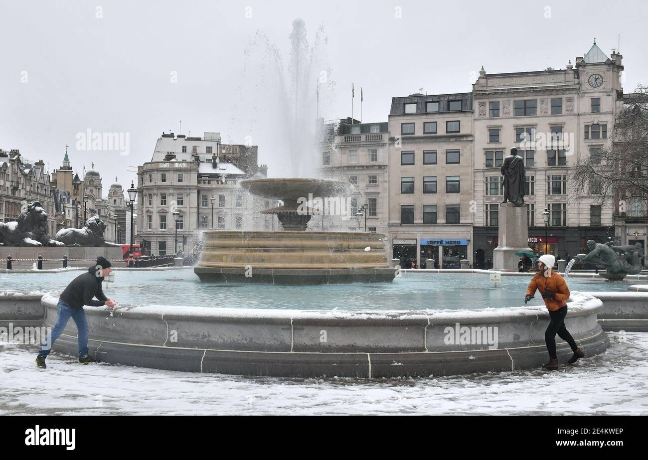 Two people have a snowball fight in Trafalgar Square, in central London ...