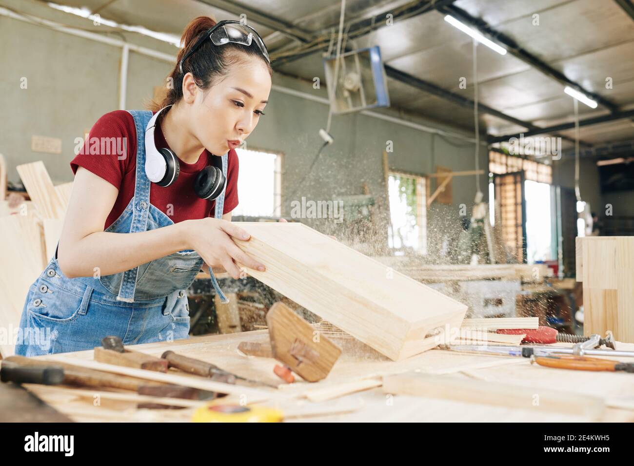 Carpenter blowing off wooden dust Stock Photo - Alamy