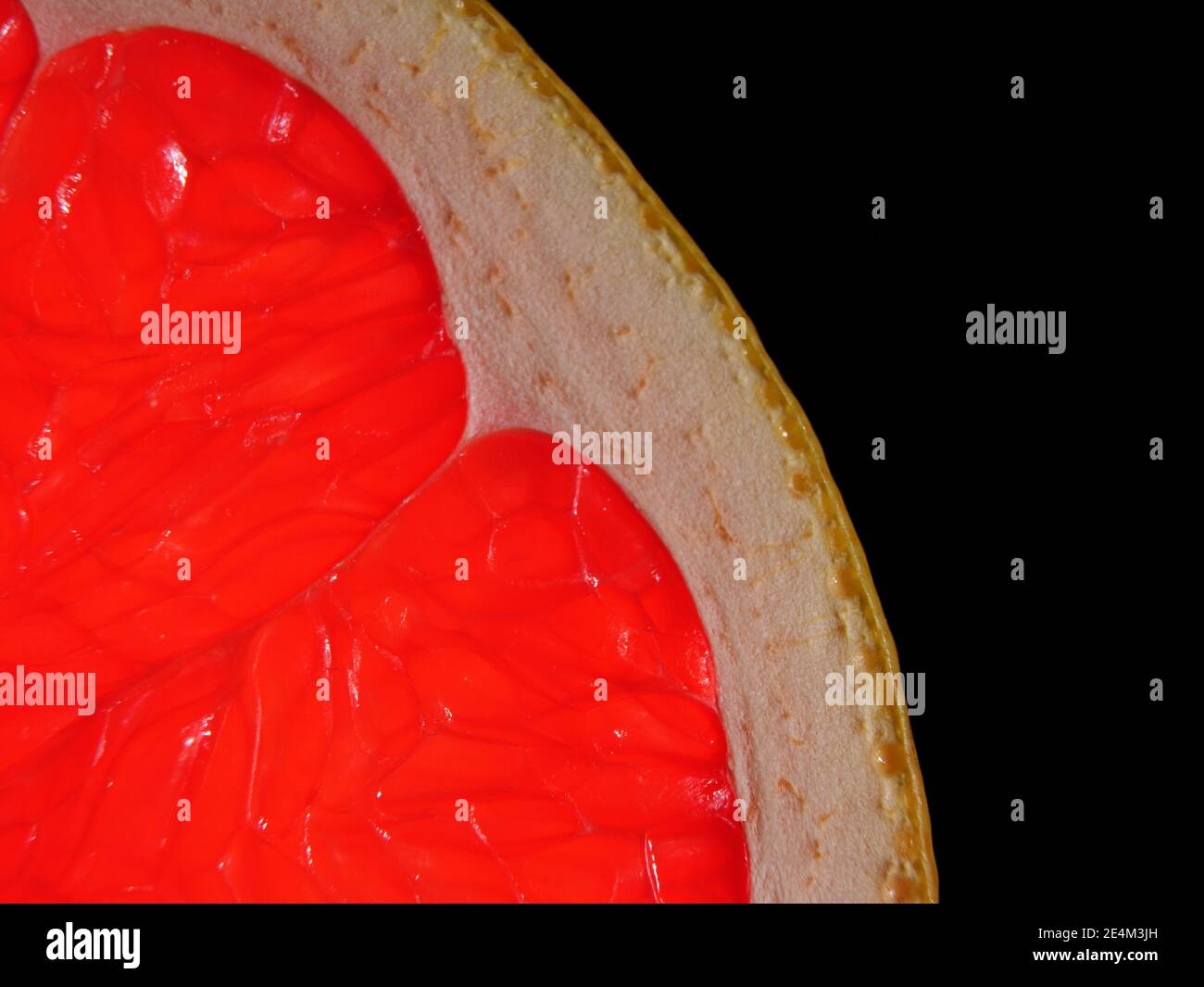 A fragment of grapefruit close-up on a black background. Organic fruit ...
