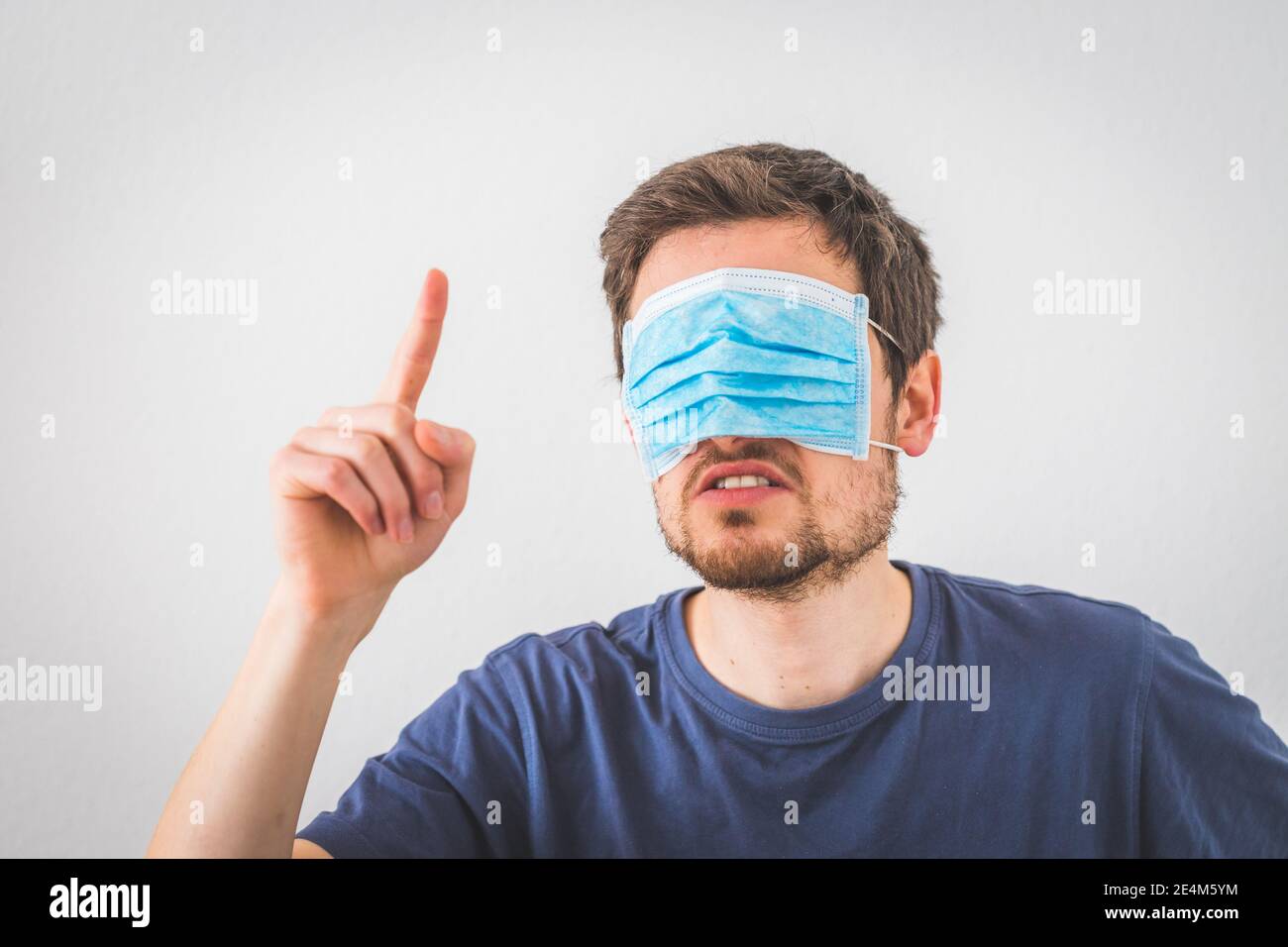 Young angry man with and face mask is gesturing angry. Conspiracy ...