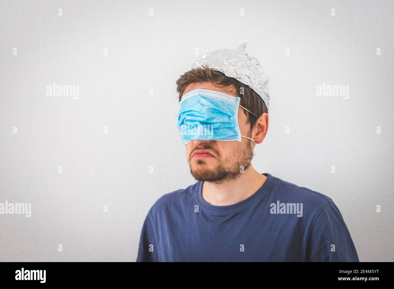 Young angry man with aluminum cap and face mask. Conspiracy theory ...