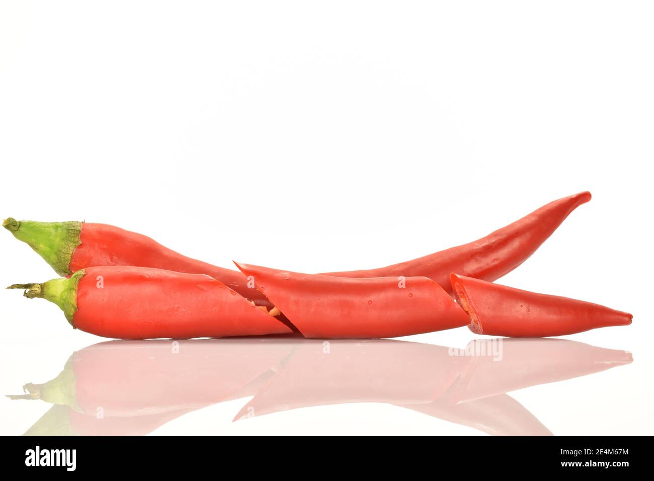 One whole spicy fresh ripe red hot pepper, and one cut into three parts ...