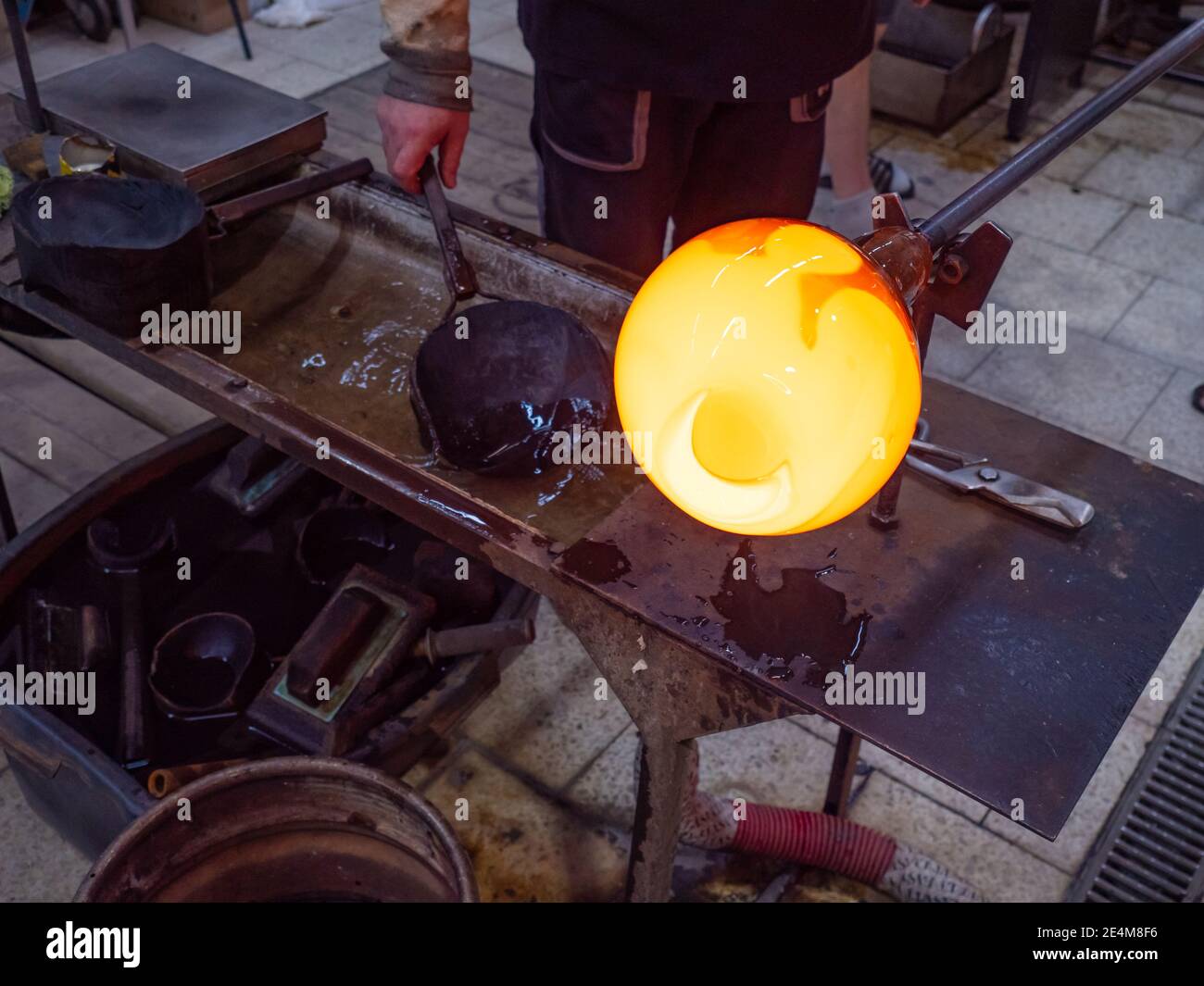 Man Hands Shaping hot glass art piece with wooden tool. Traditional ...