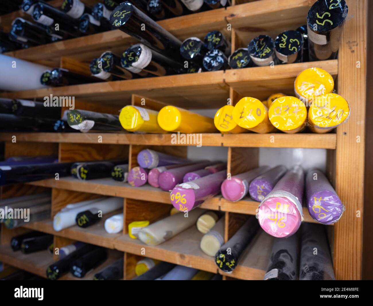 Glassy colorful rods. Wooden stand with pigment glass rods for work ...