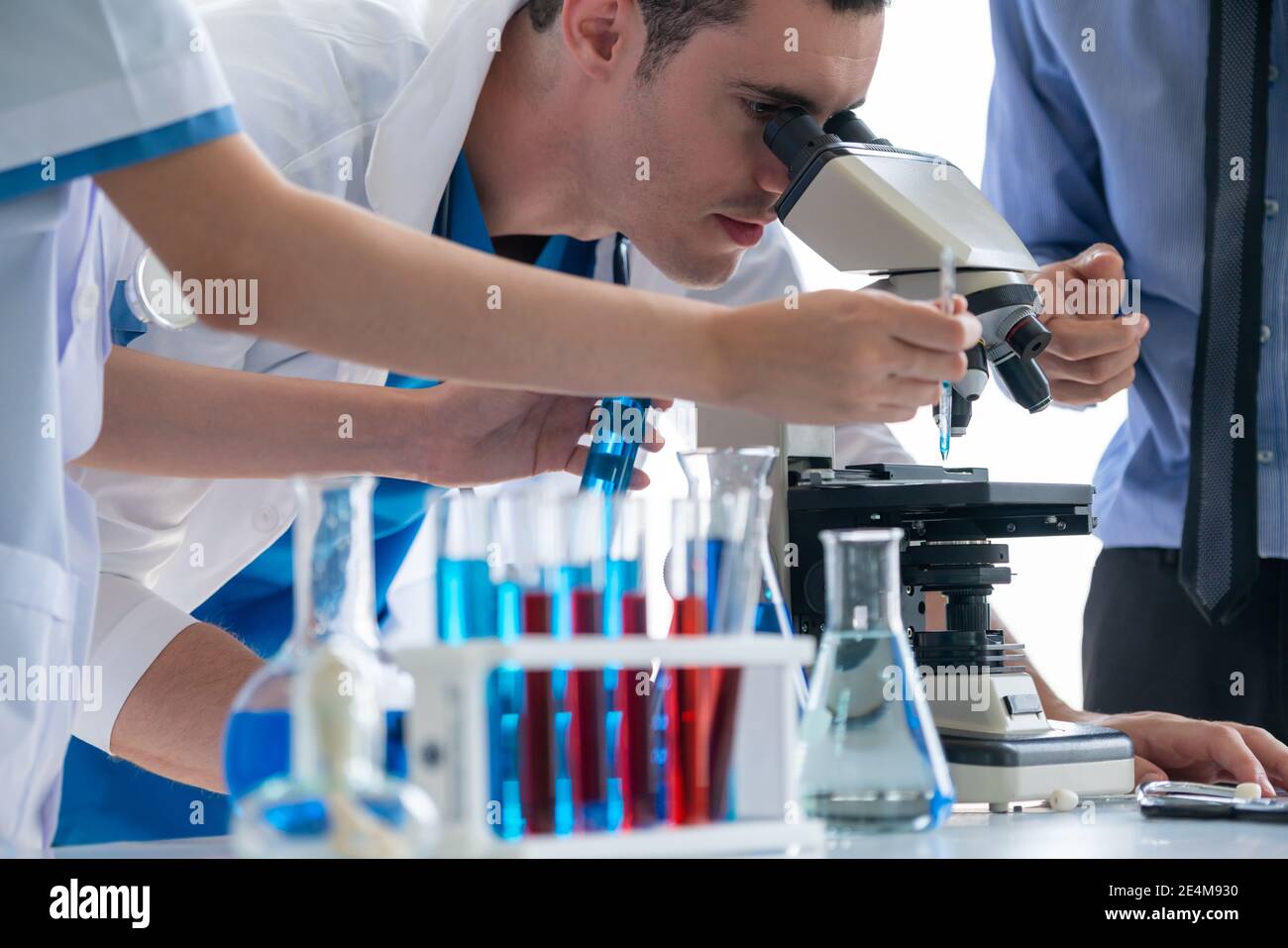 Group of scientists wearing lab coat working in laboratory while ...
