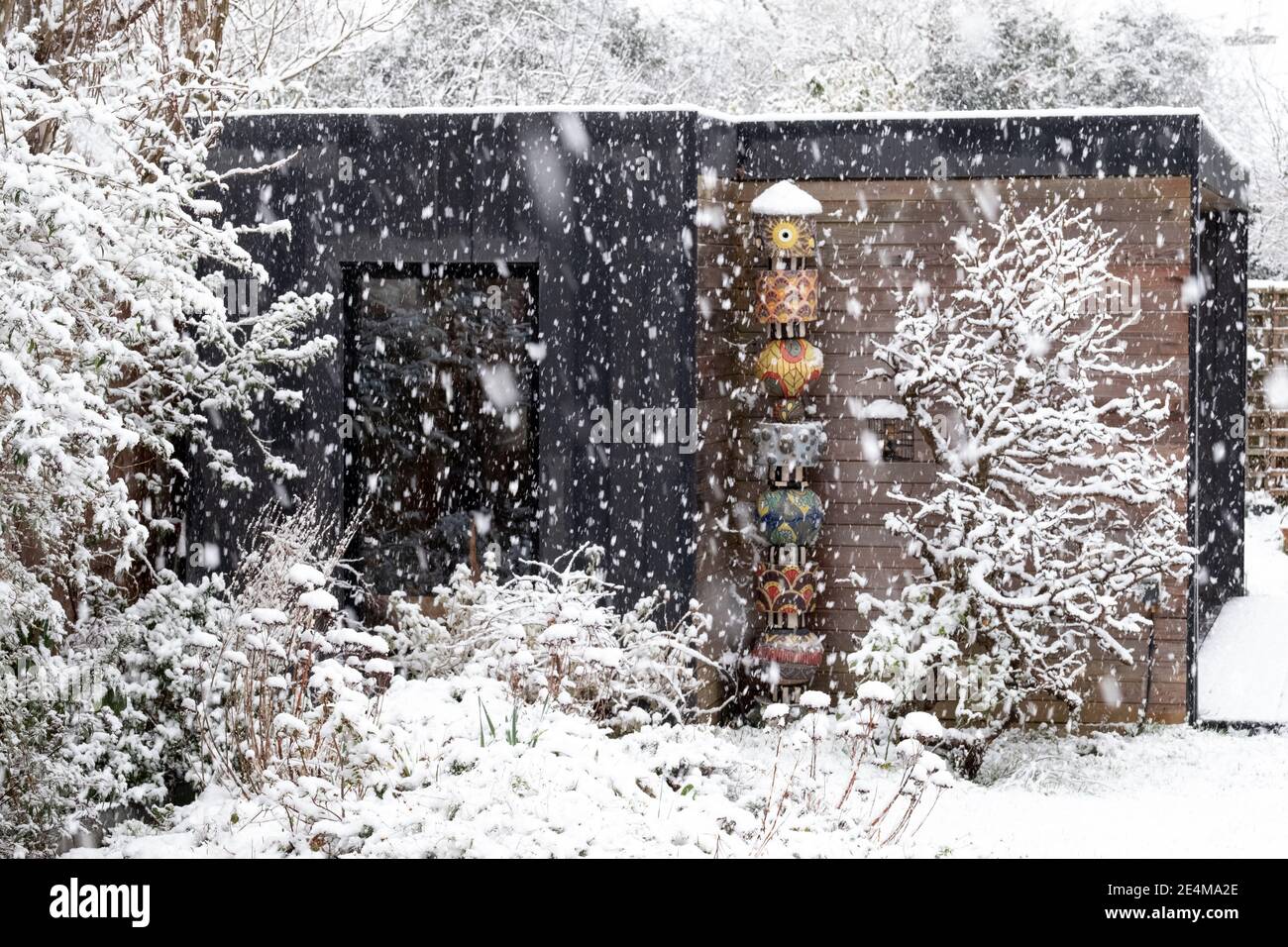Heavy snow falling during a cold snap, in a suburban garden with garden ...