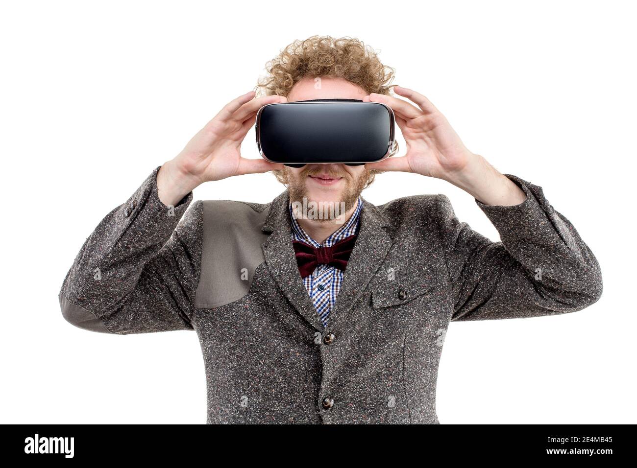 Young curly-haired businessman wearing brown suit use a VR headset and ...