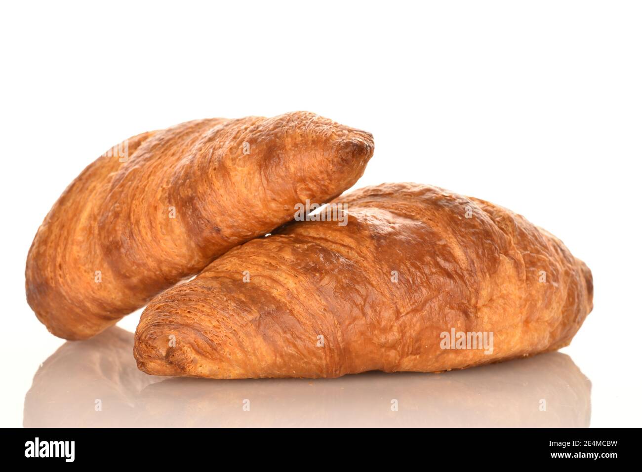 Two whole fragrant sweet fresh crispy croissants on a white background ...