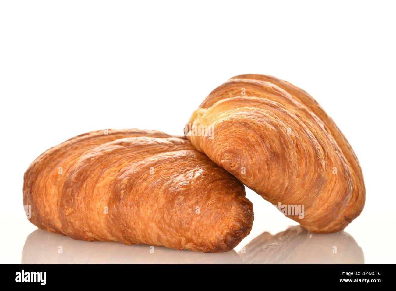 Two whole fragrant sweet fresh crispy croissants on a white background ...