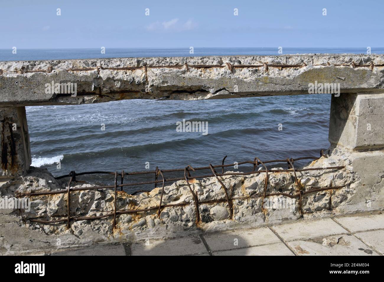 Damaged sea wall in Portugal with rusty concrete reinforcing wires ...