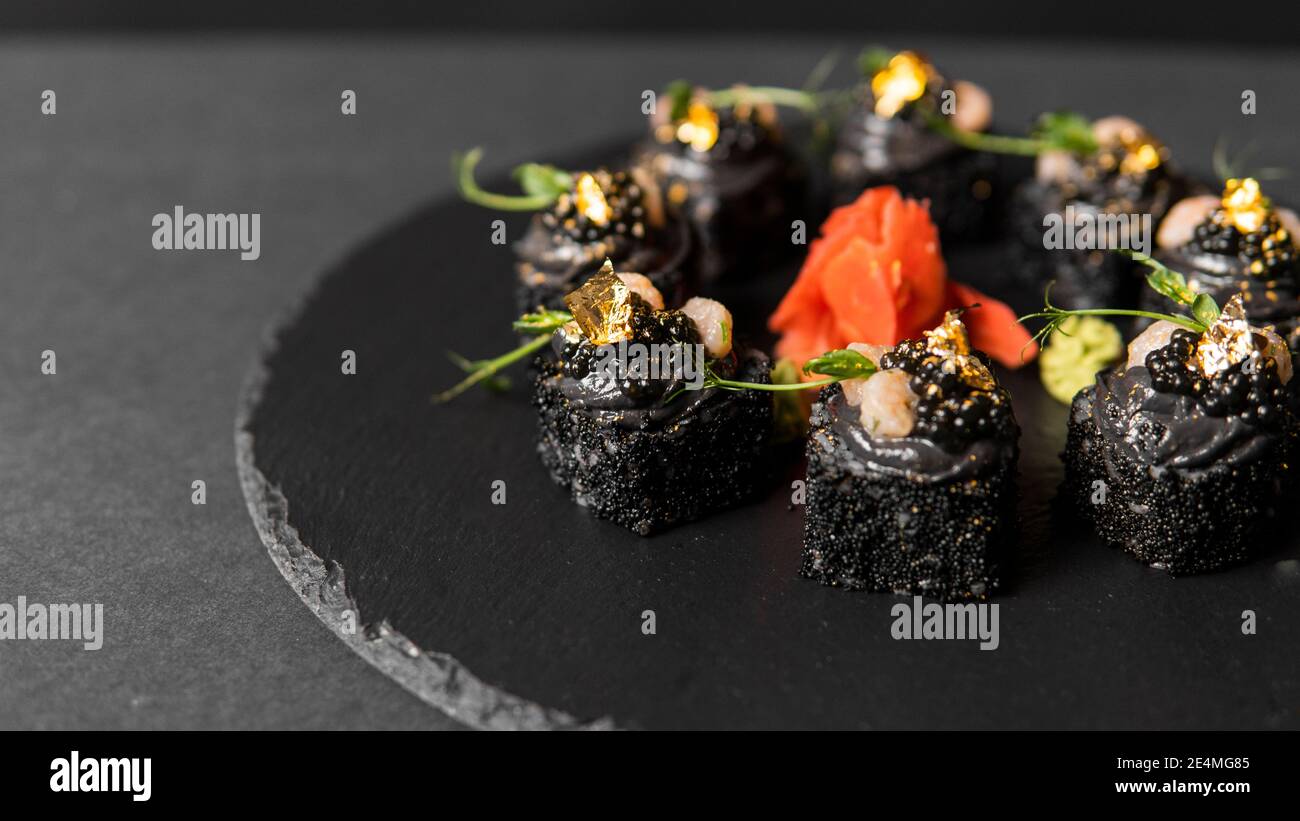 Sushi roll with nori, black rice, crab meat, cucumber, avocado, smoked ...