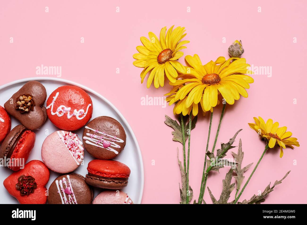 Assorted valentines day macarons on a pastel pink background with ...