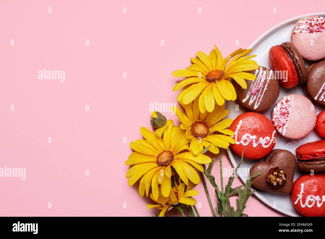 Assorted valentines day macarons on a pastel pink background with the ...