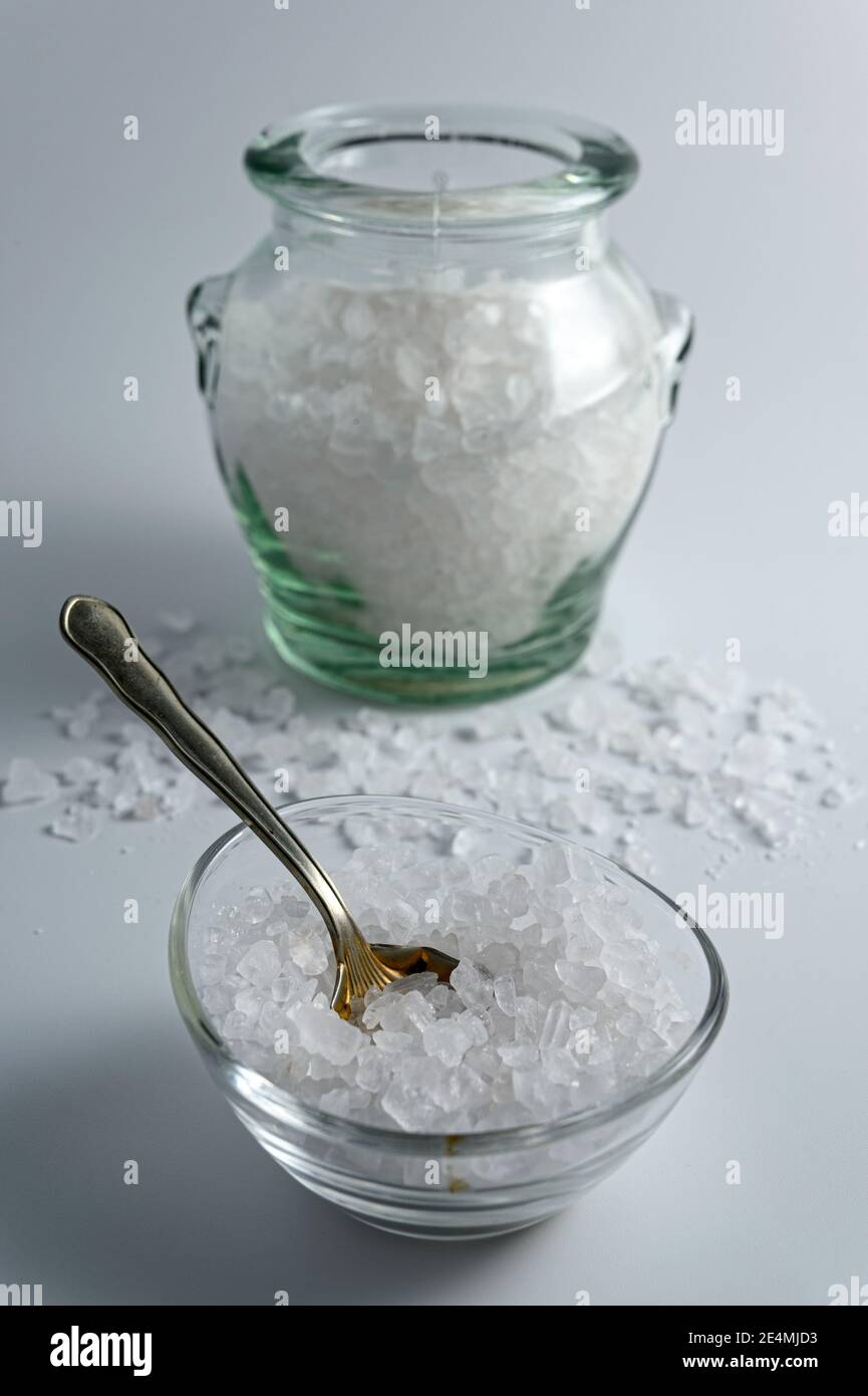 Glass jar and bowl of sea salt on white background Stock Photo - Alamy