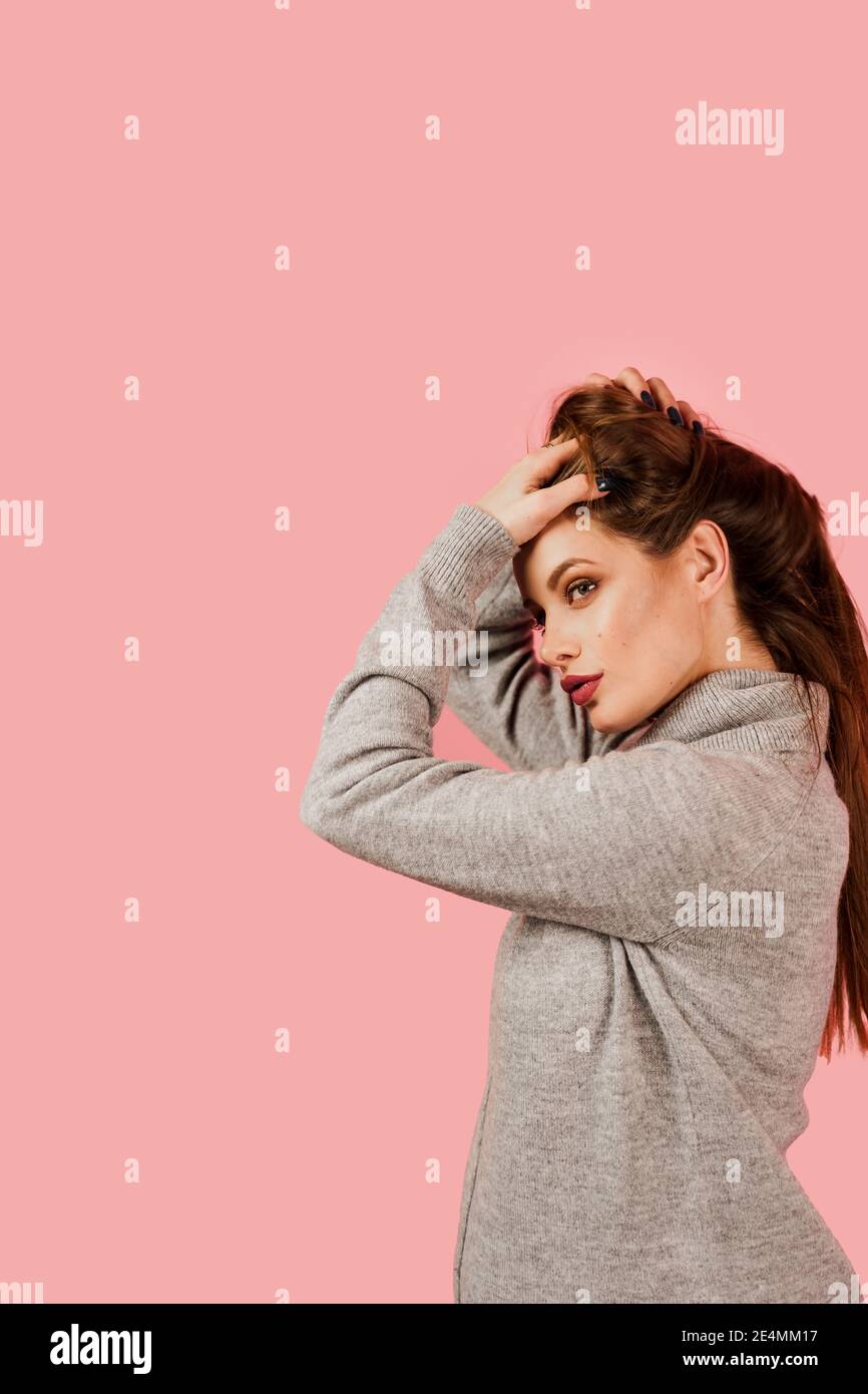 Pregnancy of a happy beautiful girl in a gray sweater on a pink ...