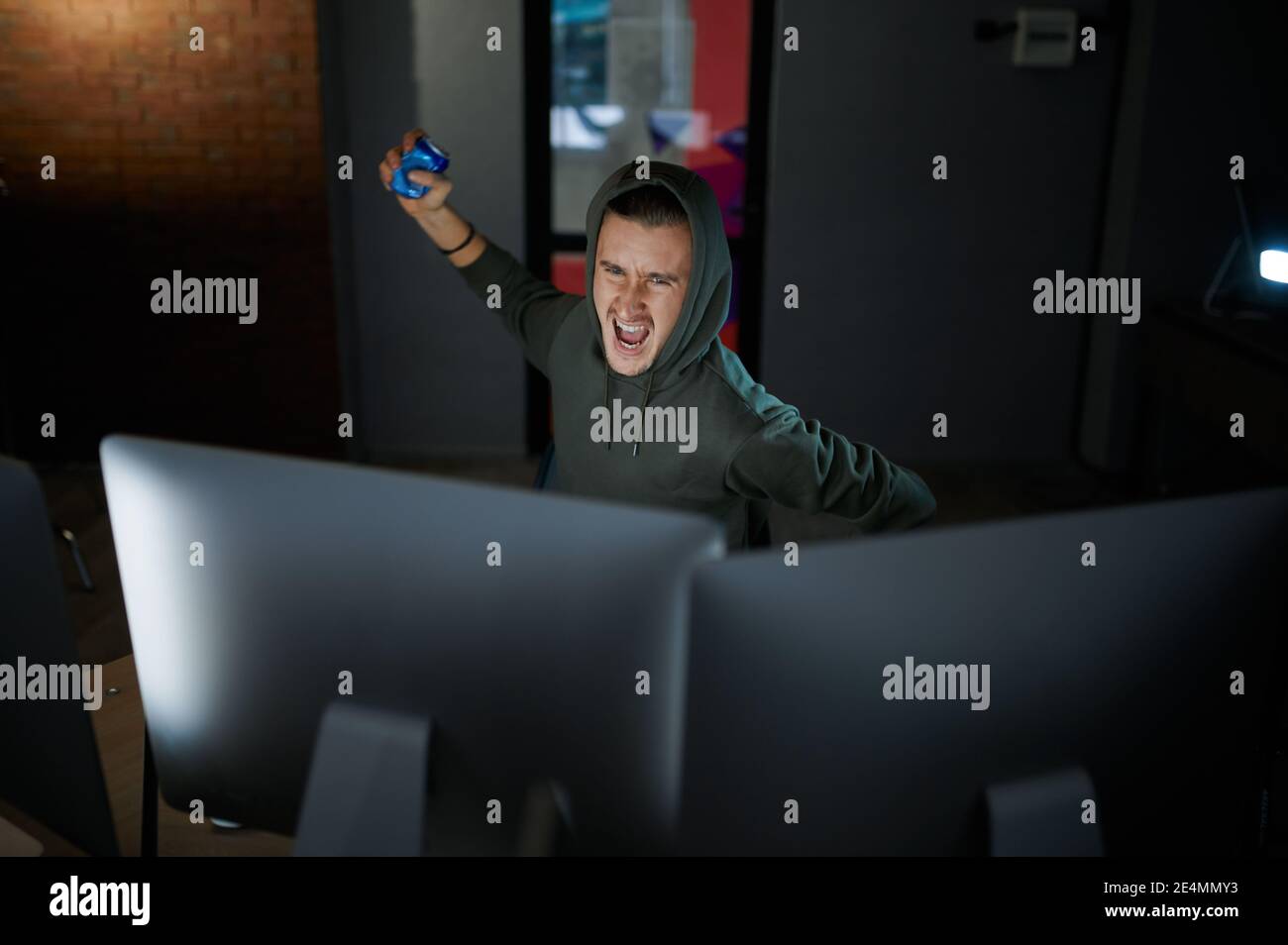 Mad male hacker in hood sitting at screens, back view Stock Photo - Alamy