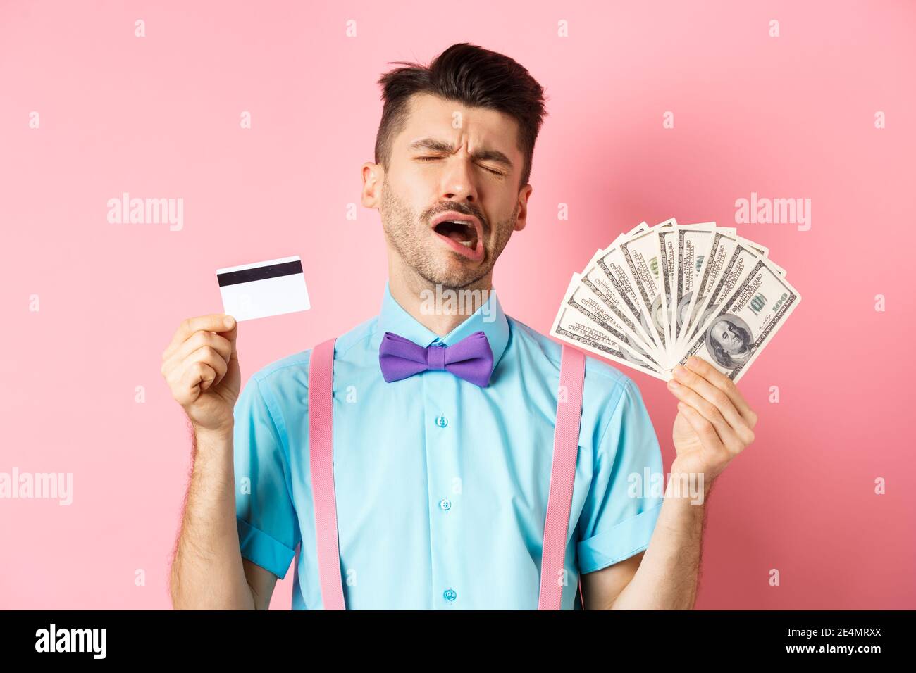 Sad crying man looking miserable, showing plastic credit card and money ...