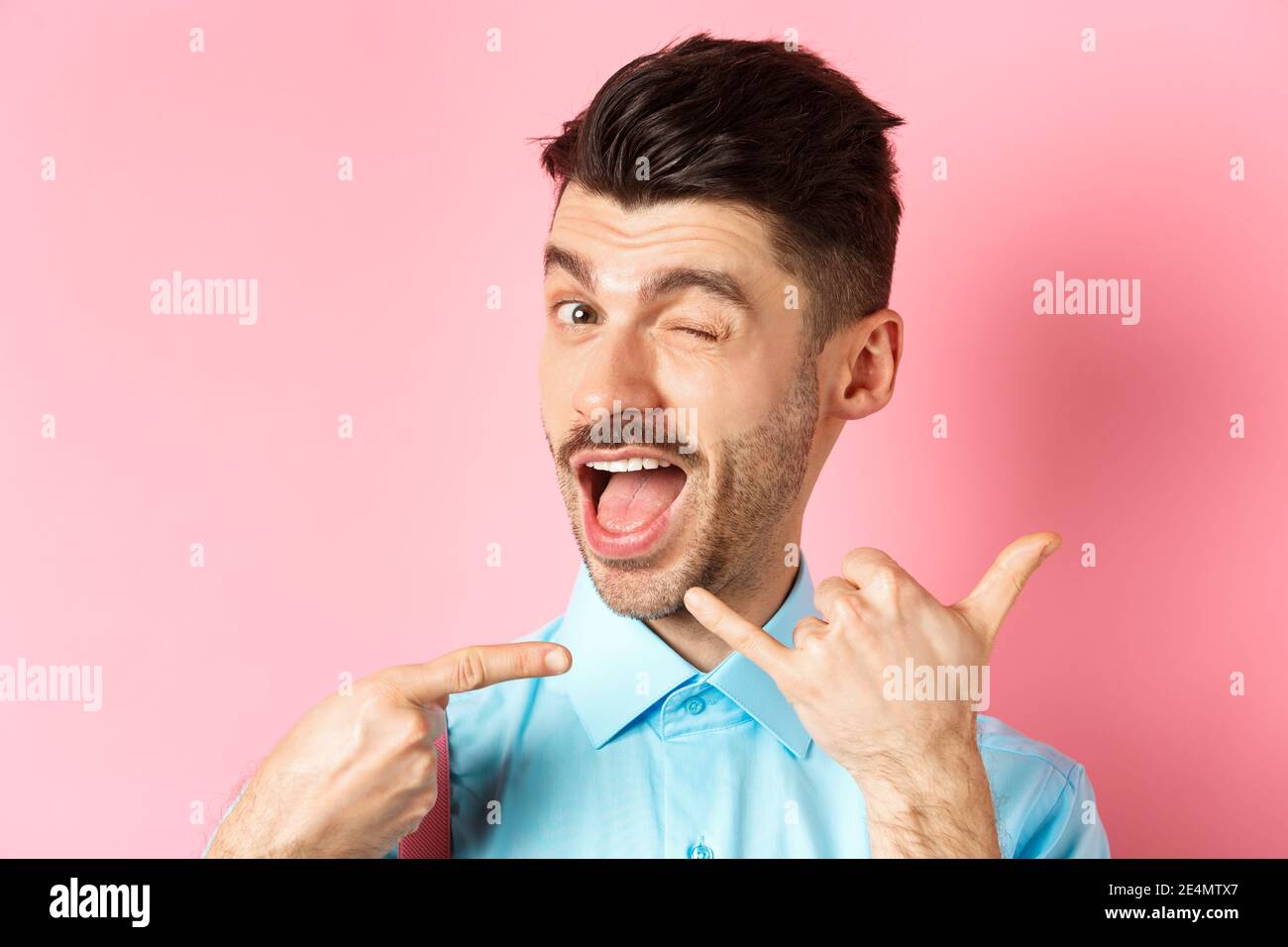 Cheeky and funny guy showing phone gesture, asking to call him and ...