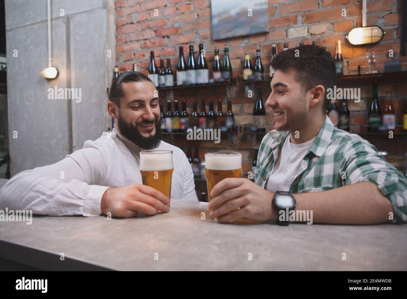 Cheerful male friends laughing, drinking beer together at the pub Stock ...