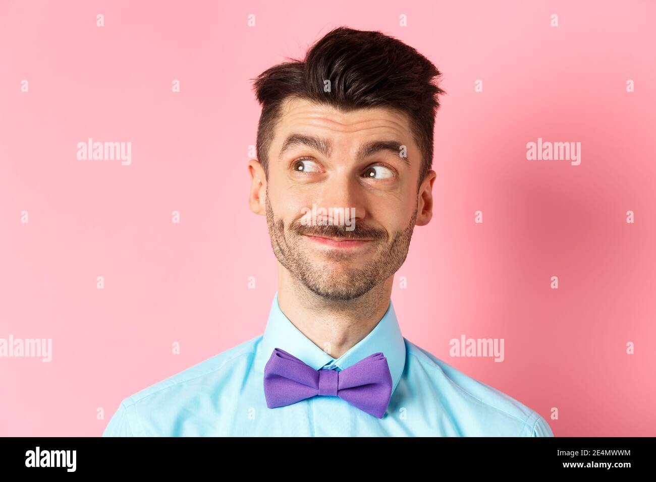 Close-up of handsome smiling guy with moustache, looking left at logo ...
