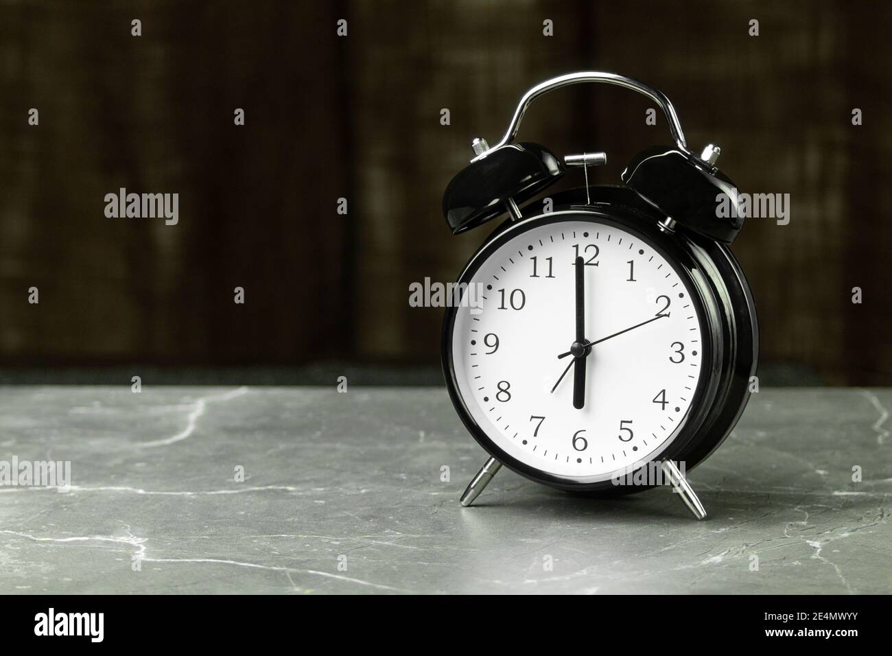 The black alarm clock hands point to six o'clock. Clock and alarm clock ...