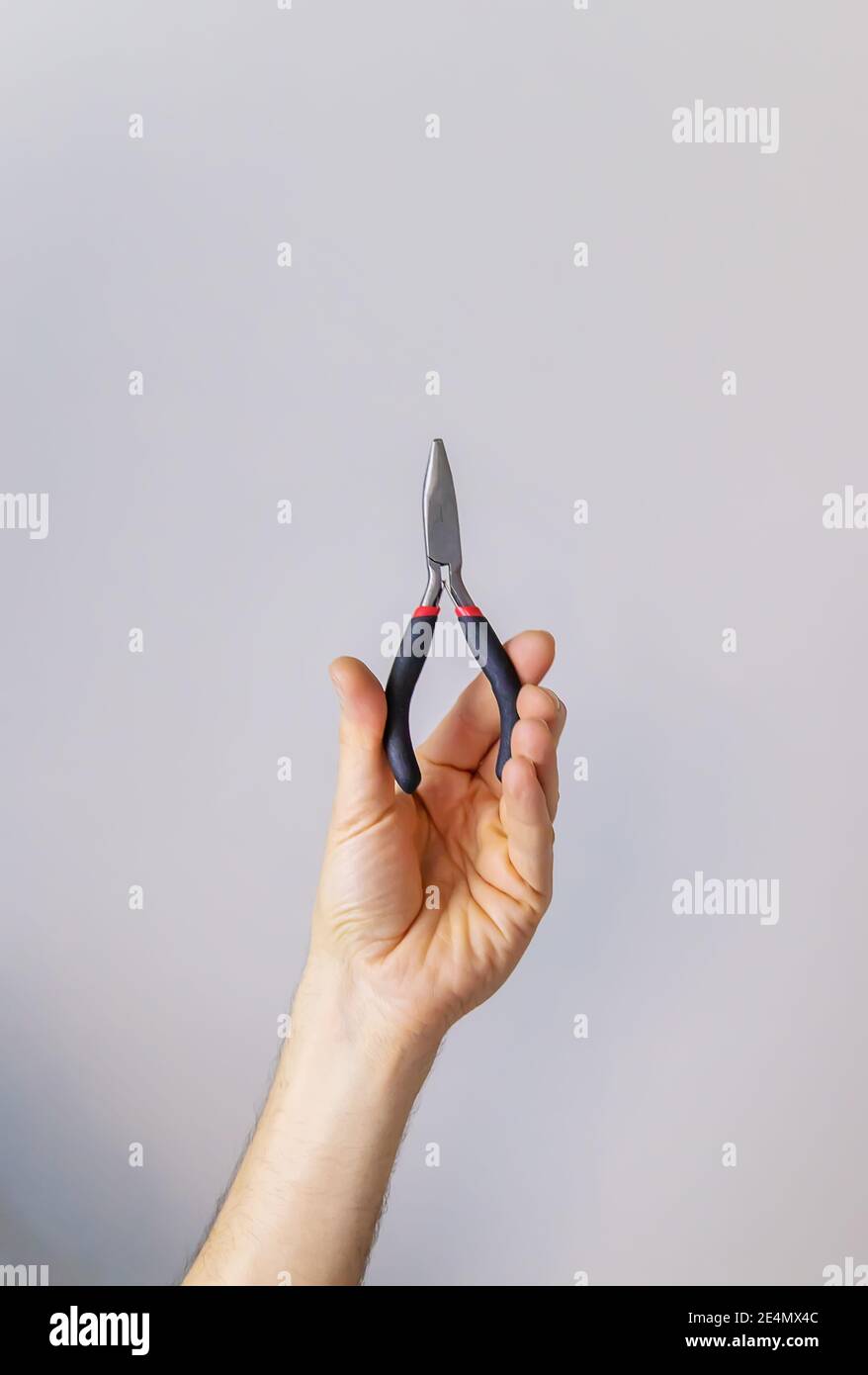 pliers for repair in the hands of a male isolate. Selective focus ...