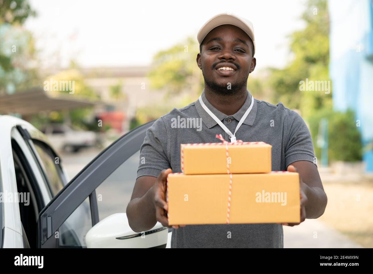 Smile african male postal delivery courier man in front of car ...