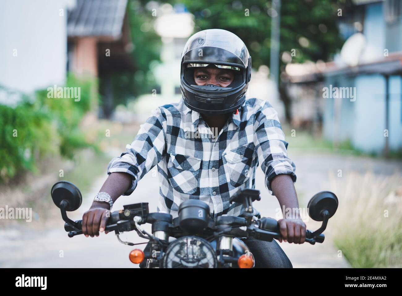 African biker in the helmet and glasses driving a motorcycle rides ...