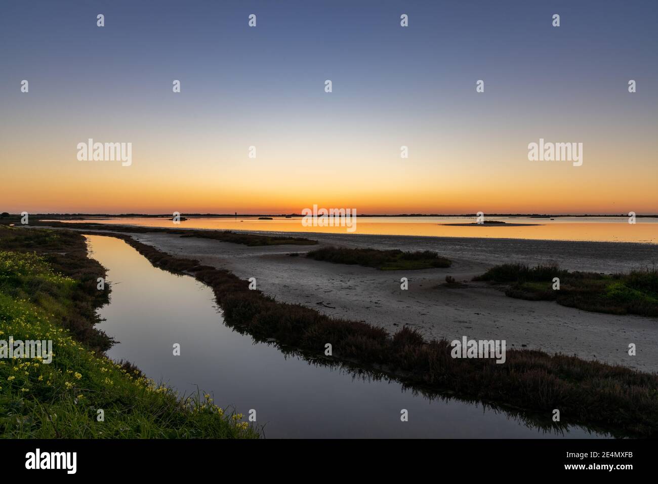 Beautiful nightfall with a colorful sky over wetlands and canals nature ...