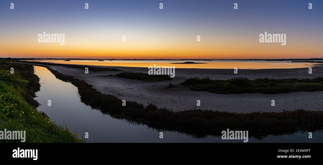 Beautiful nightfall with a colorful sky over wetlands and canals nature ...