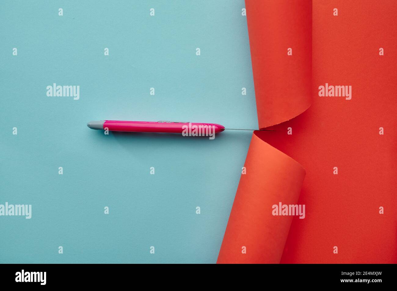 Knife cuts red paper, blue background, stationery Stock Photo - Alamy