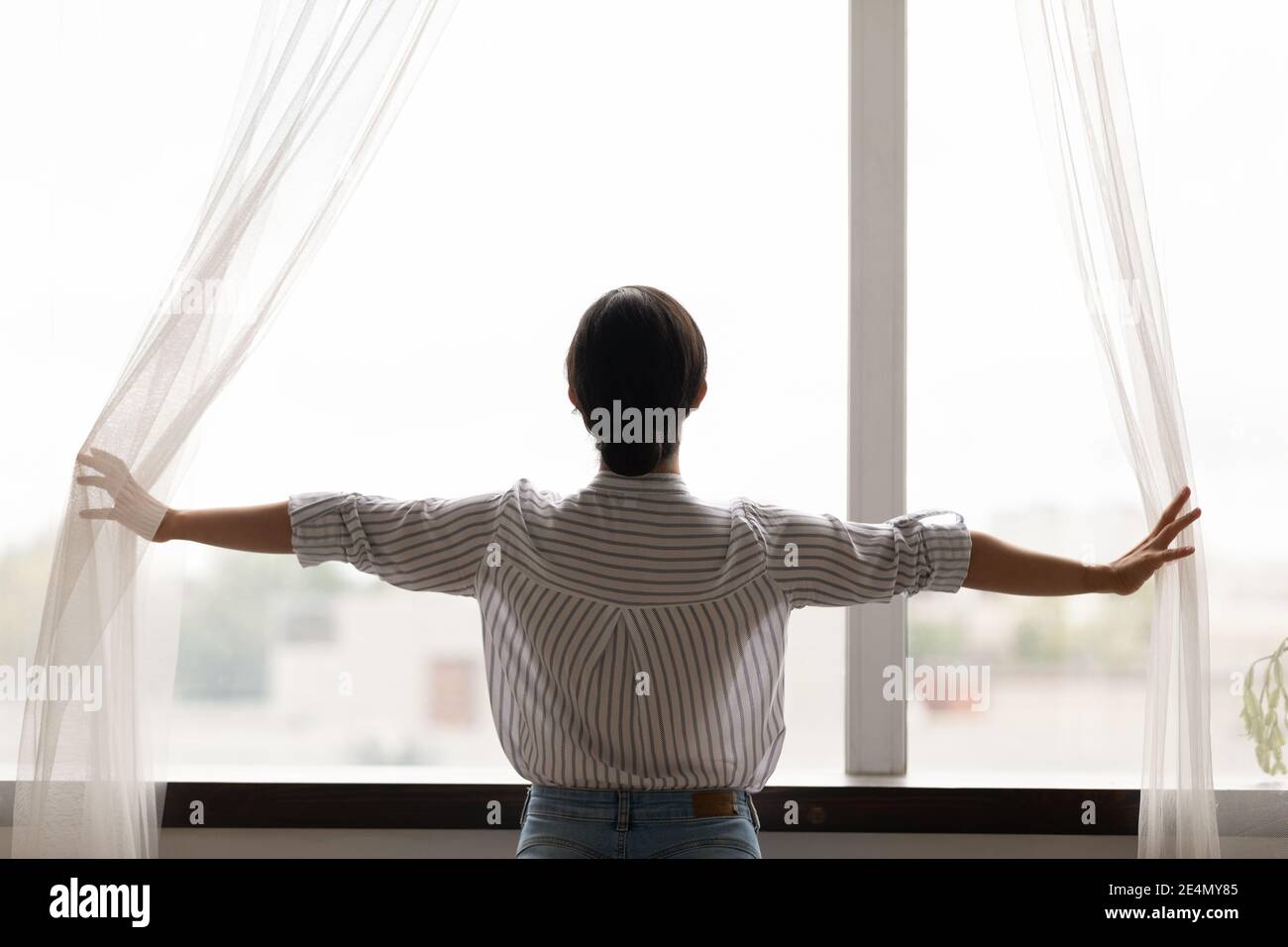 Millennial lady pull curtains back meet morning aim for positive Stock ...