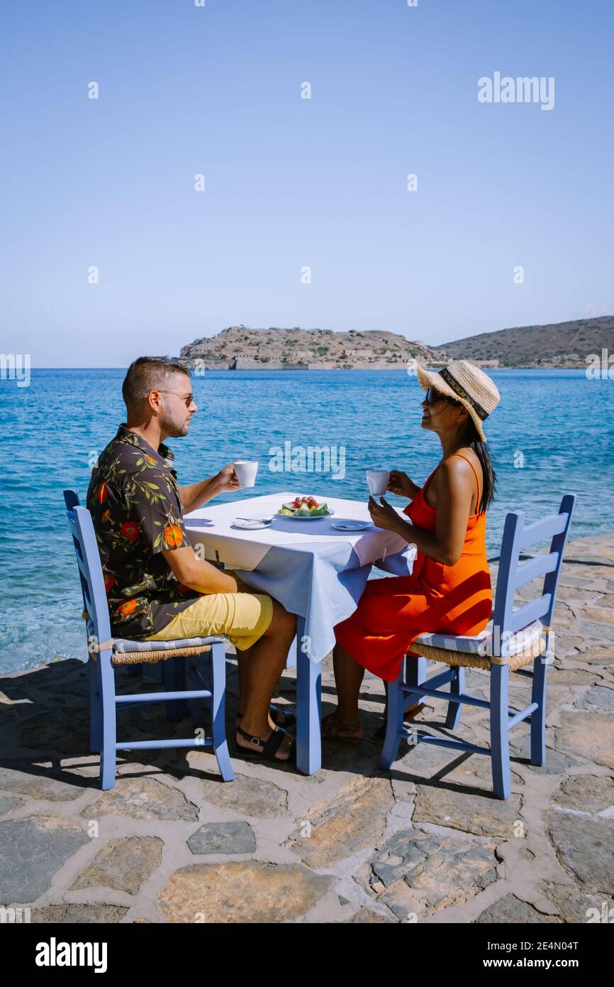 couple of men and woman on the beach of Plaka Crete looking out over ...