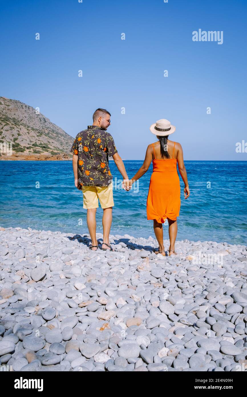 couple of men and woman on the beach of Plaka Crete looking out over ...