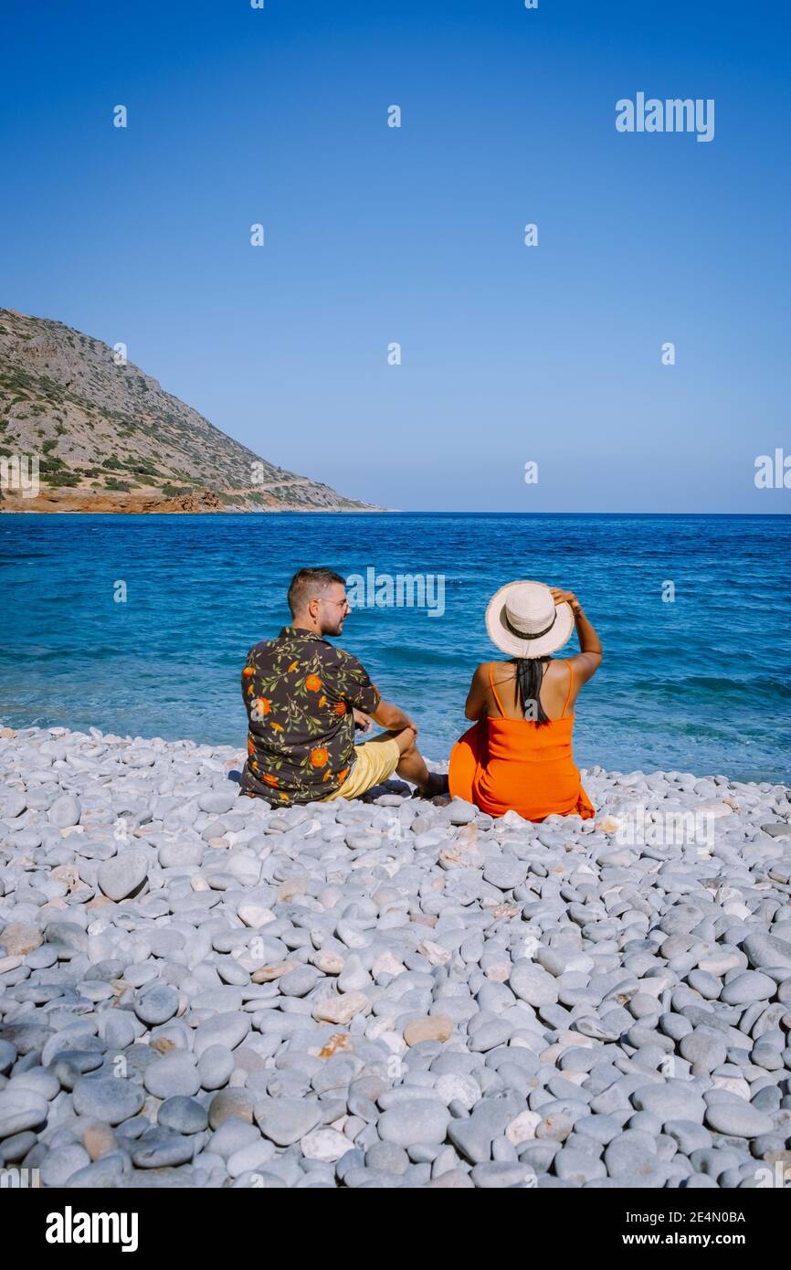 couple of men and woman on the beach of Plaka Crete looking out over ...