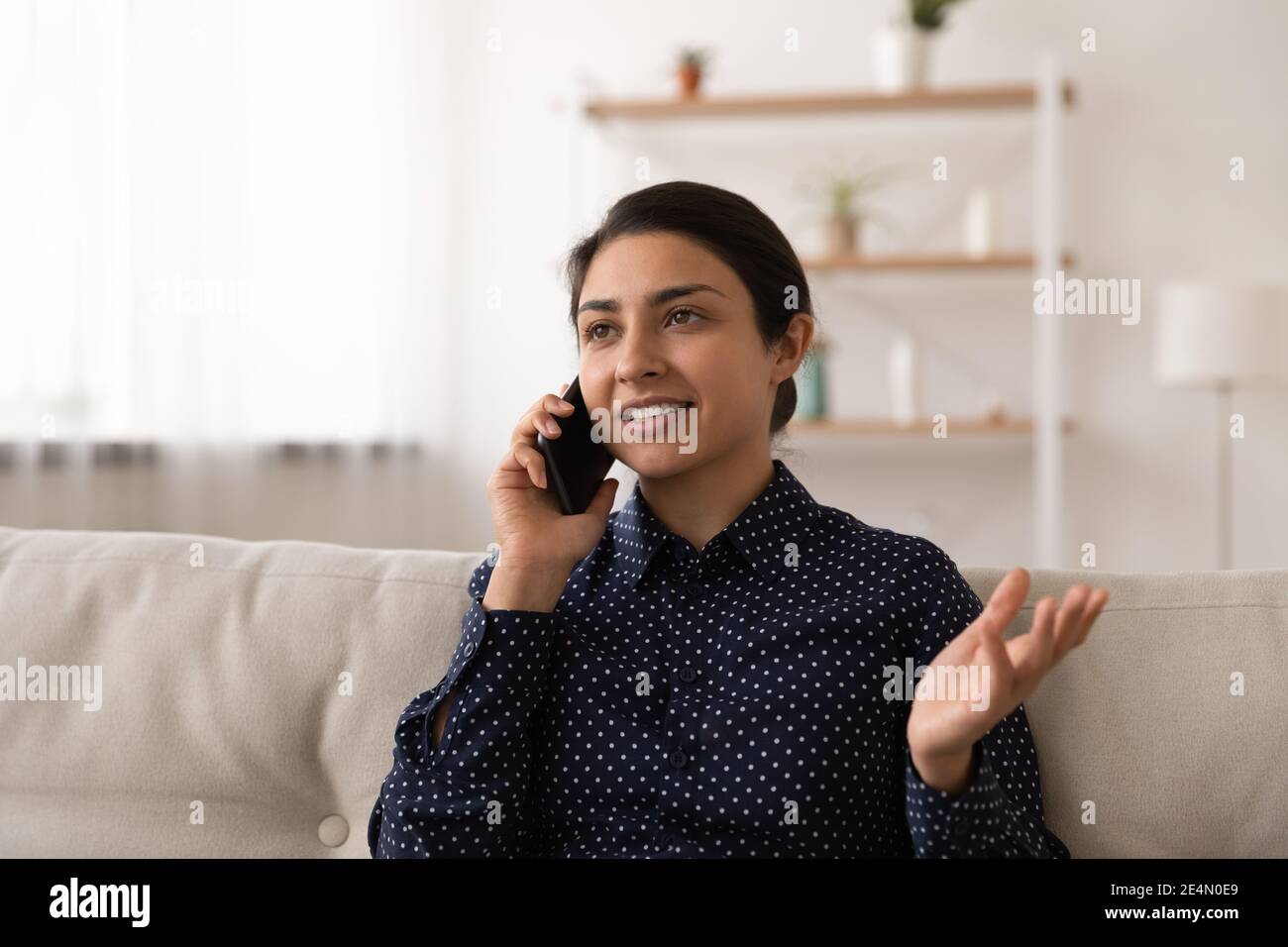 Young indian female caller relax at home enjoy telephone conversation ...