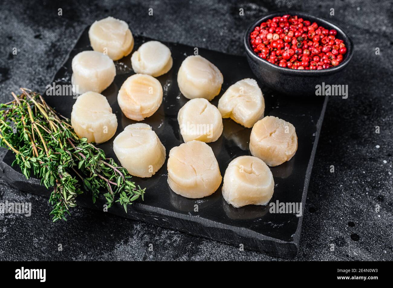 Seafood fresh scallops meat on a marble board. Black background. Top ...