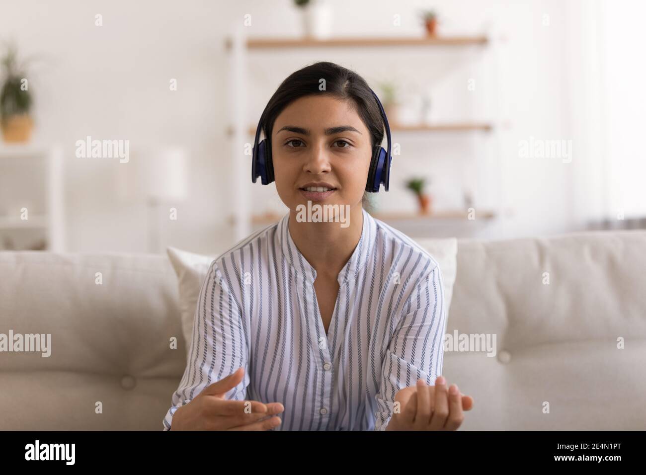 Portrait of confident indian female expert in headphones helping client ...