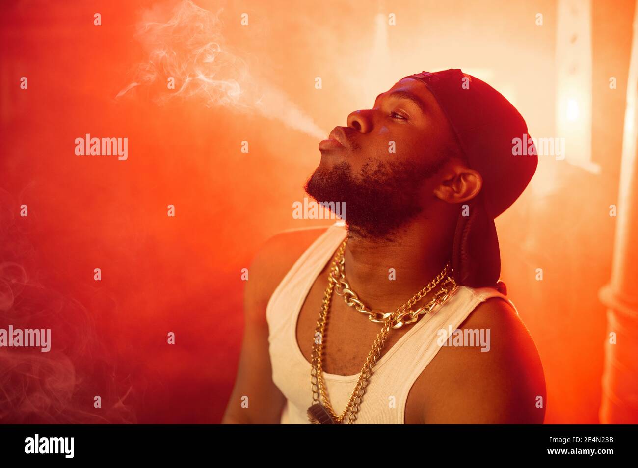 Stylish rapper exhales smoke in studio Stock Photo - Alamy