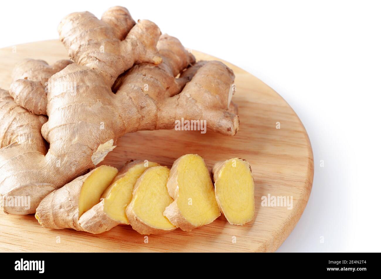 Fresh sliced ginger root on a round cutting board. Healthy food and ...