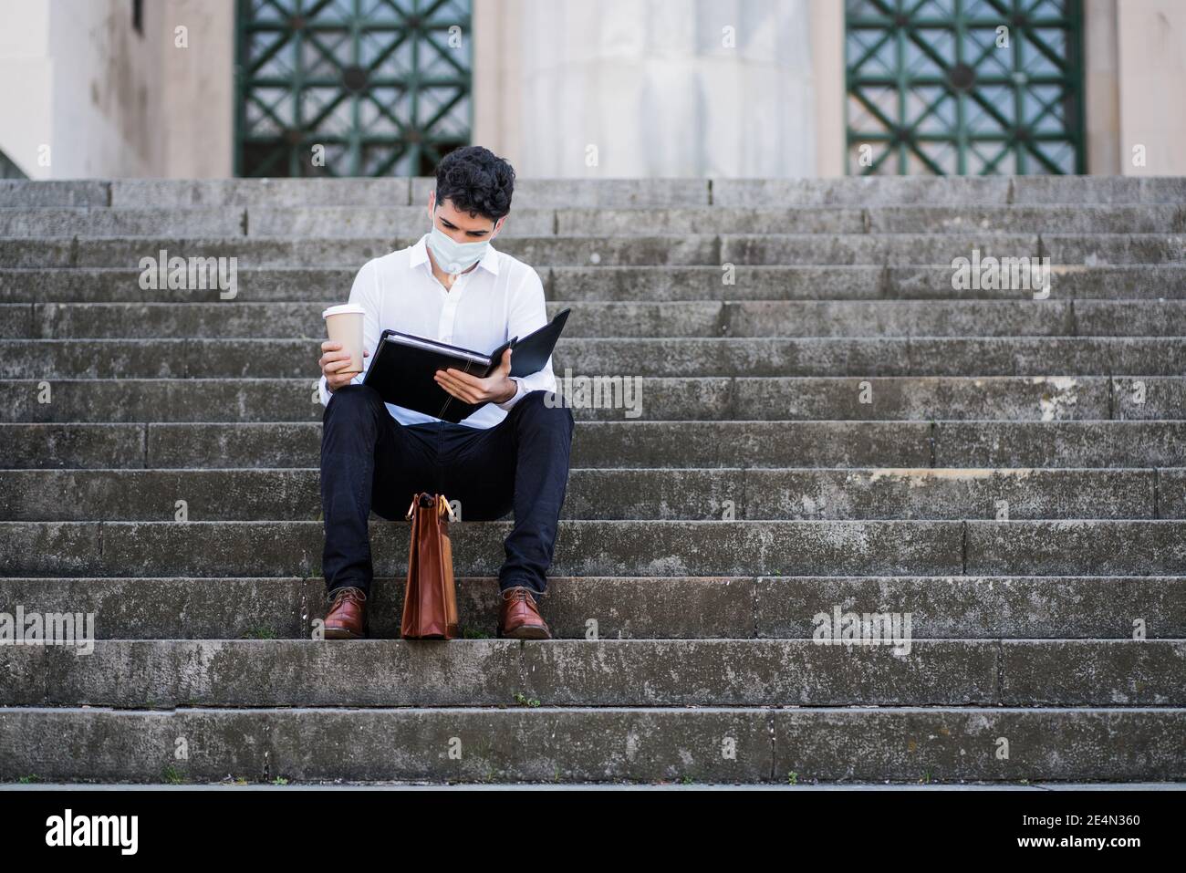Business man reading files outdoors Stock Photo - Alamy